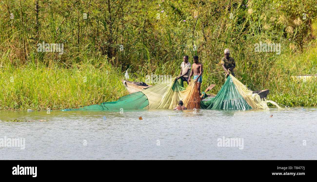 Malawian men fishing with nets from a boat in Shire River Malawi Stock ...