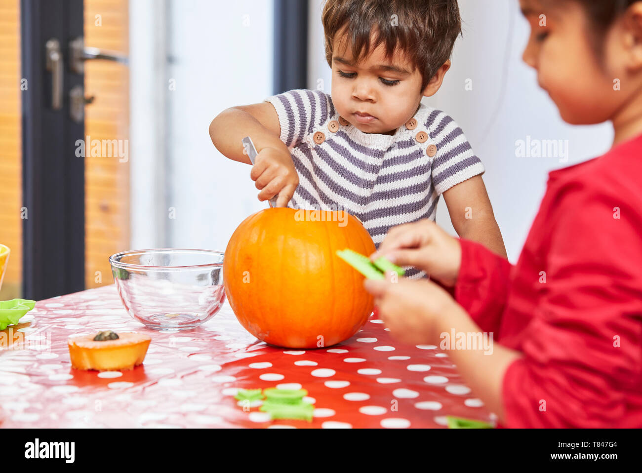 Boy gutting pumpkin in kitchen Stock Photo - Alamy