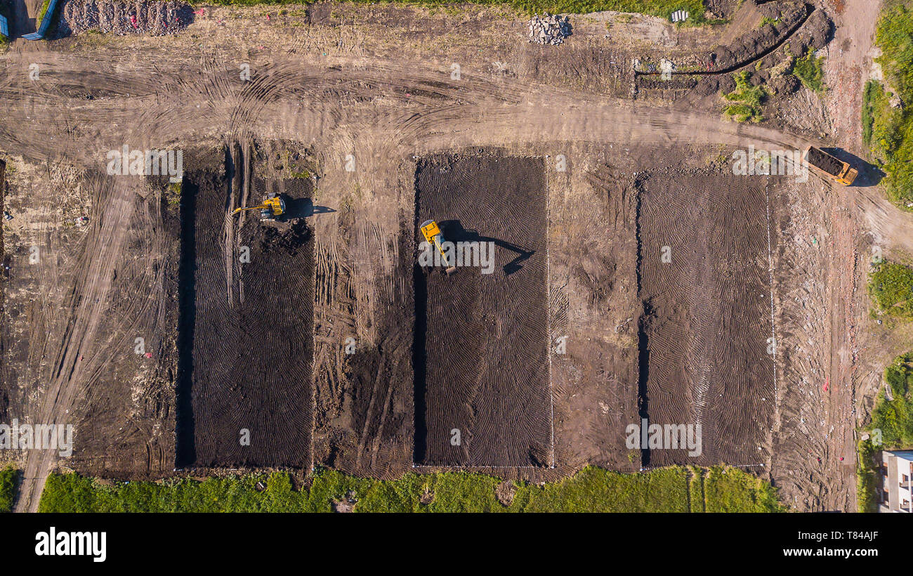 Aerial construction - top down view of an excavator and truck working ...