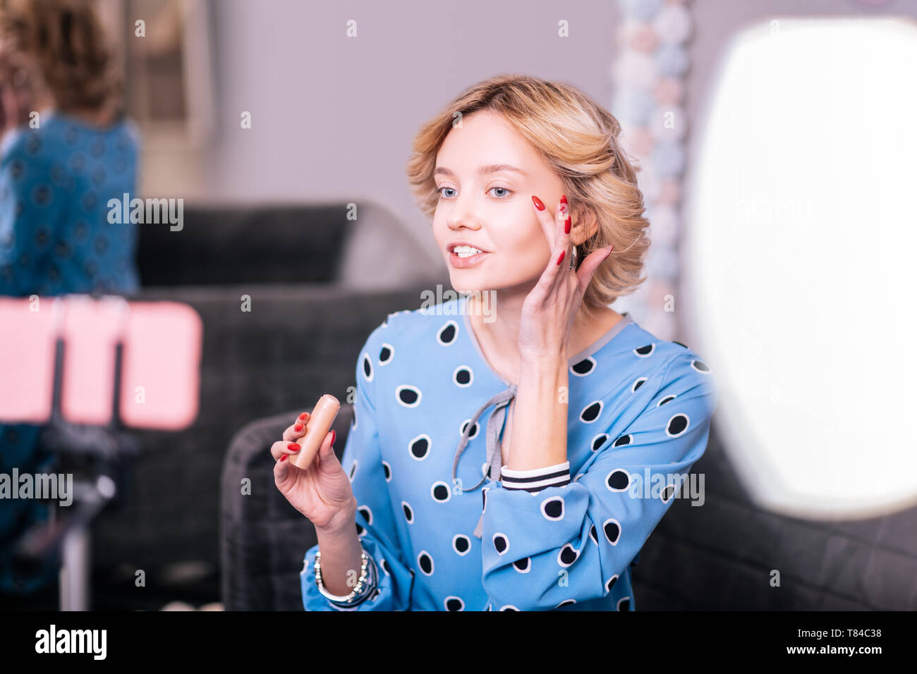 Woman speaking while putting face bronzer and filming video Stock Photo ...