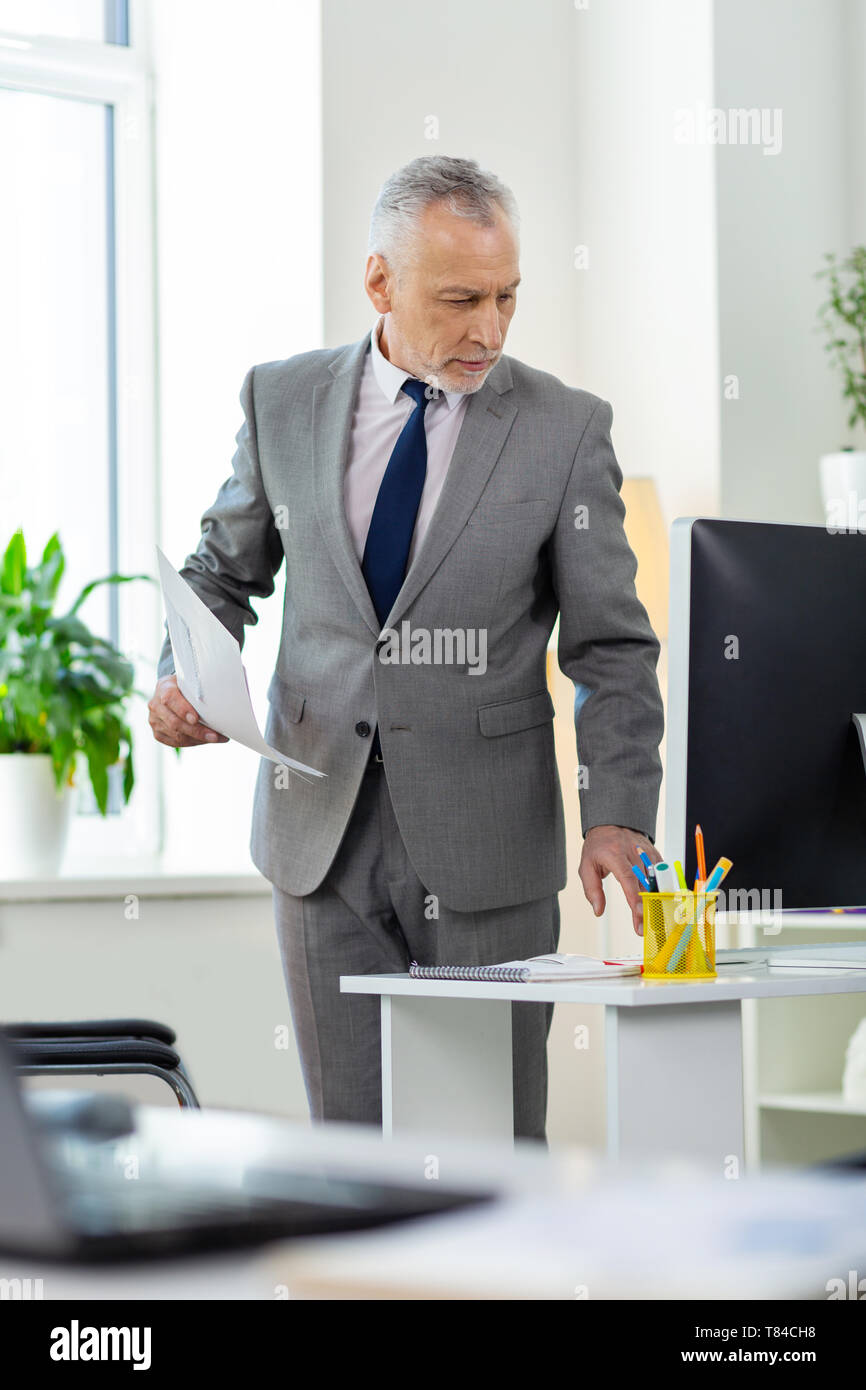 Curious strict grey-haired man in grey costume and black tie Stock ...