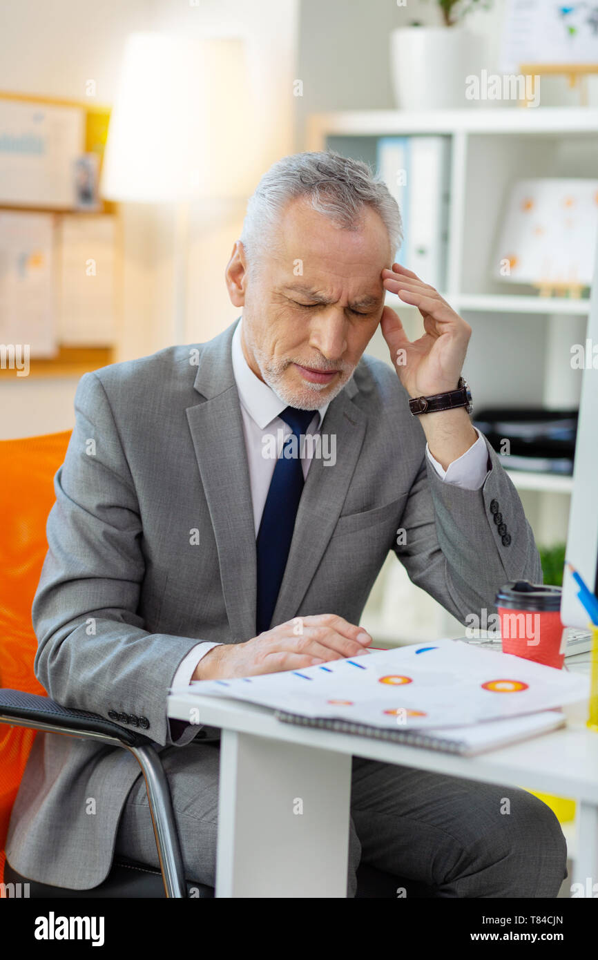 Senior miserable man having extreme headache at work Stock Photo - Alamy