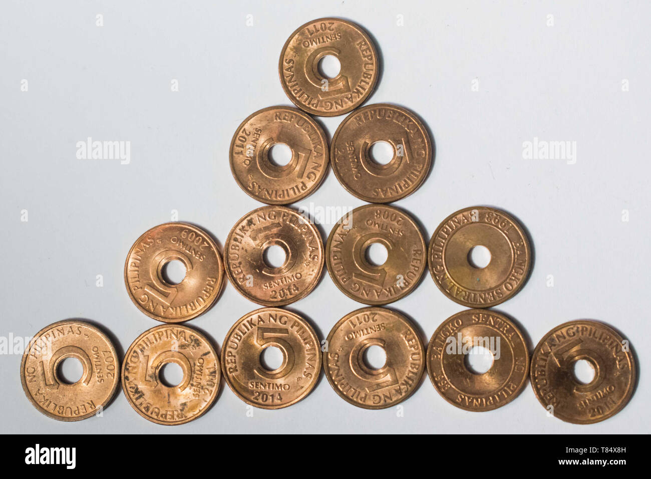 Old copper pennies laid on a white background forming a triangle shape ...