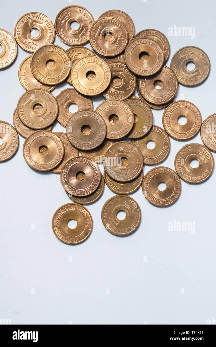 Philippine coins isolated on white background, stacked small gold coins ...