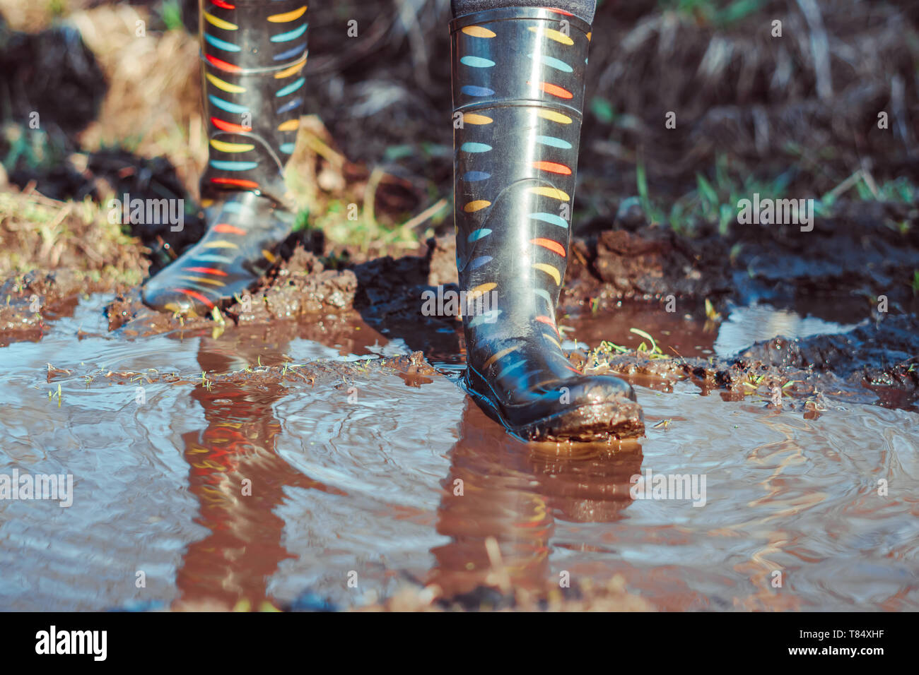 Dirty brown boots on the mud when raining Stock Photo - Alamy