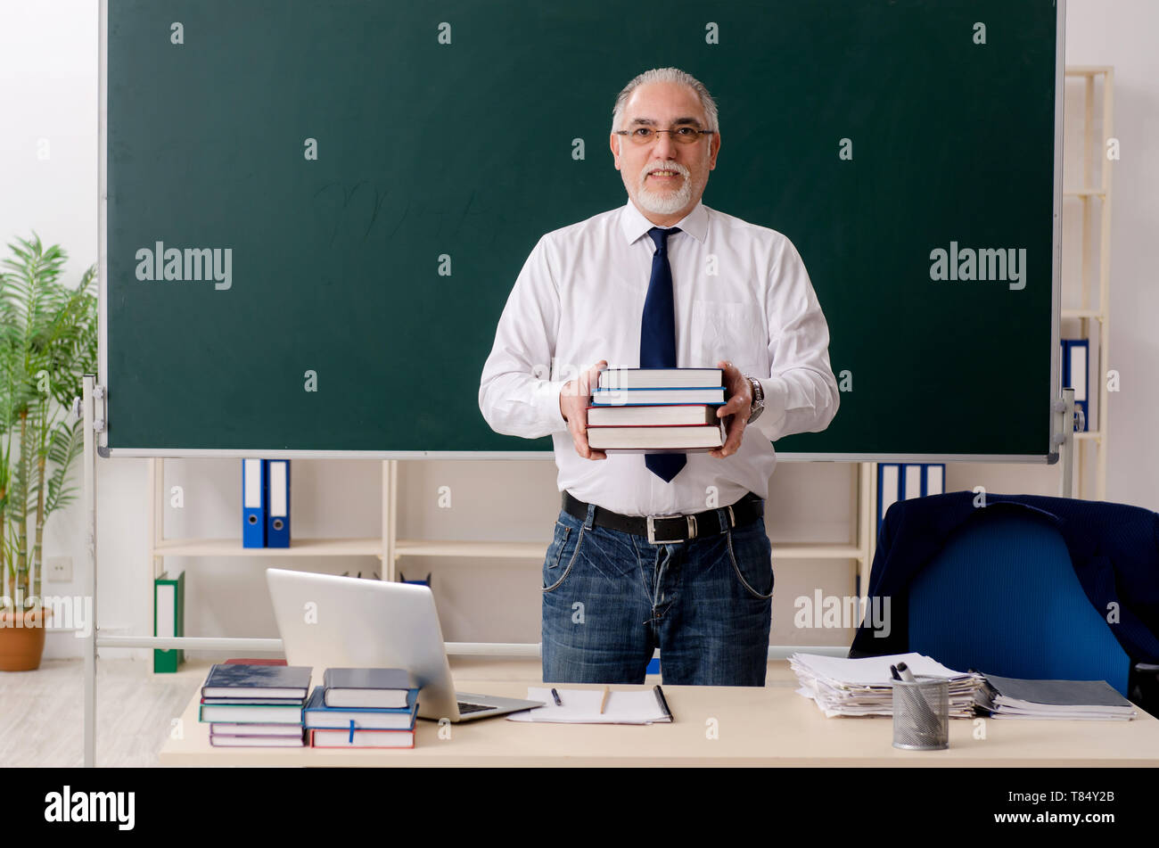 Aged male teacher in front of chalkboard Stock Photo - Alamy