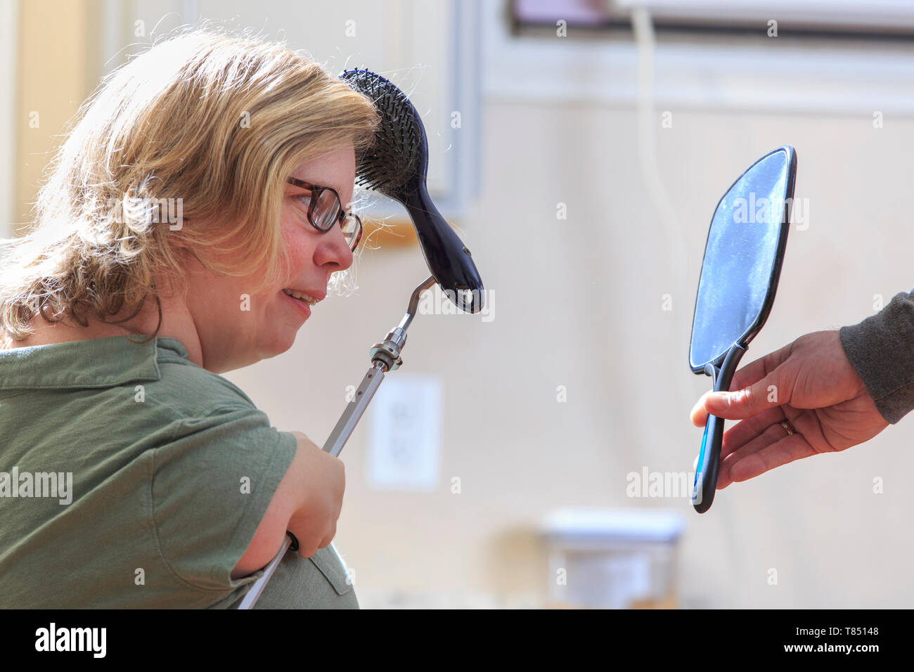 Woman with TAR Syndrome using an attachment to brush her hair Stock ...