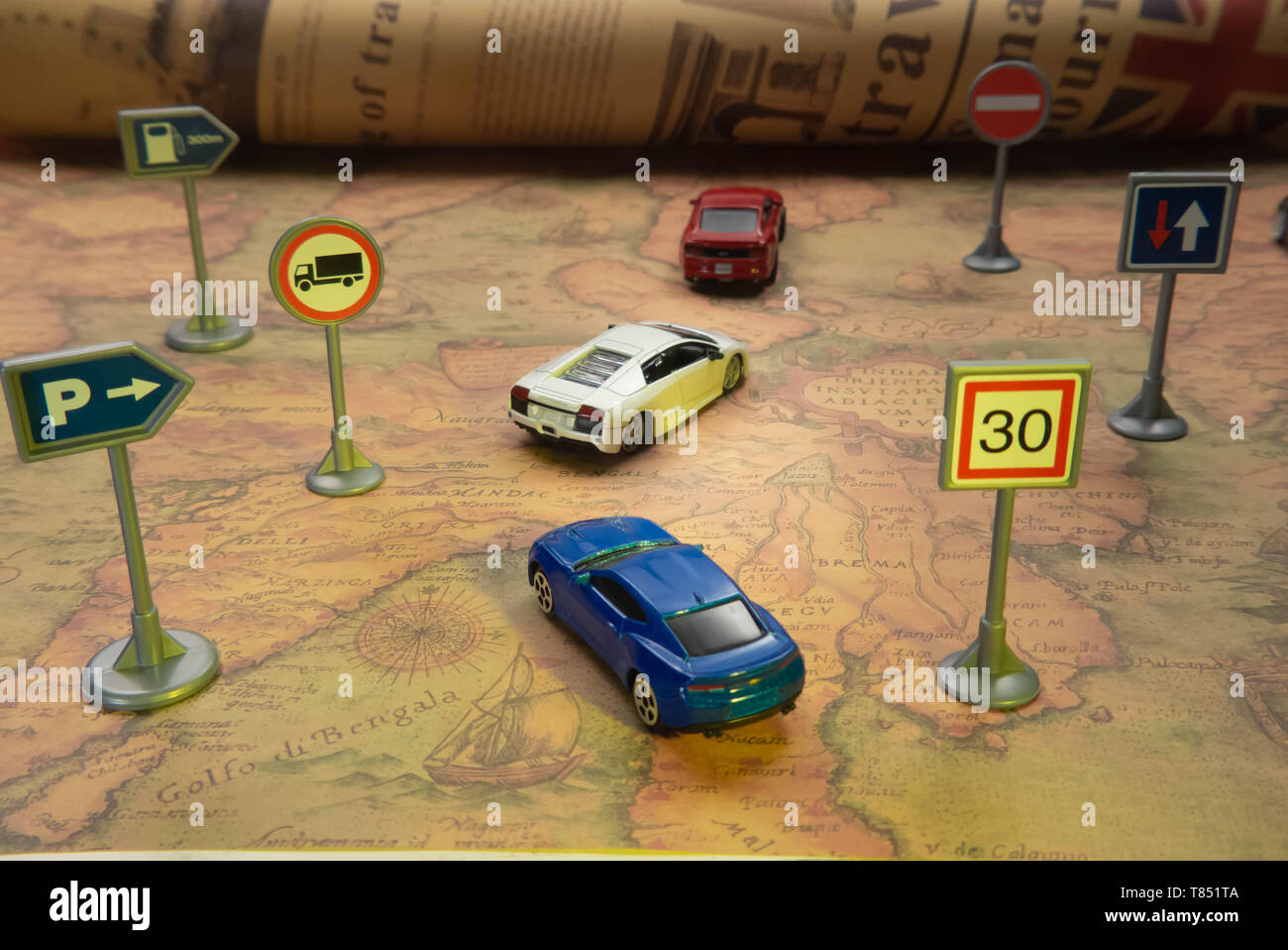Travel concept. Toy car on vintage World map with road sign. Closeup ...