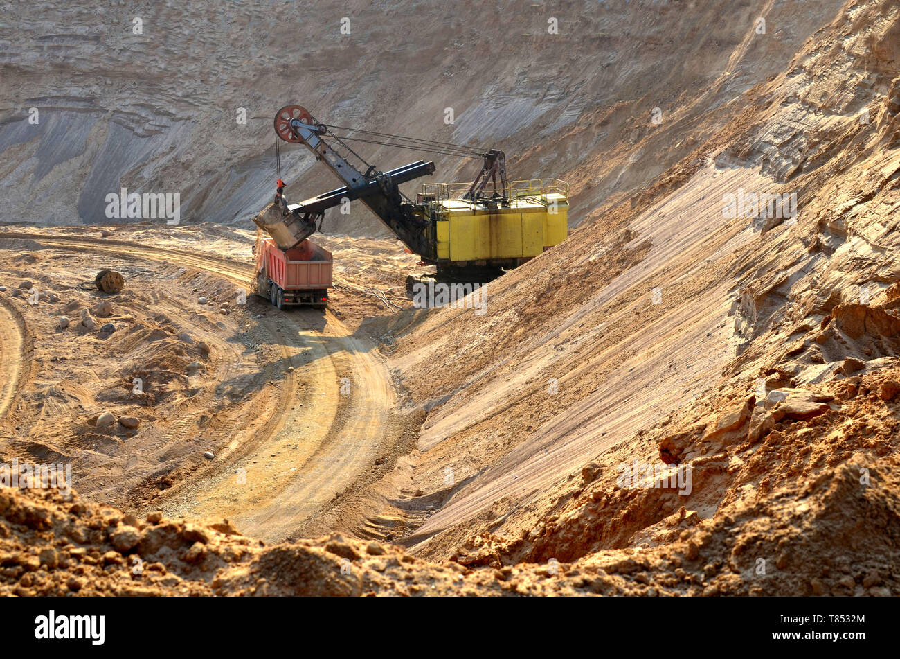 Quarry excavator loading sand or into dump truck at opencast ...