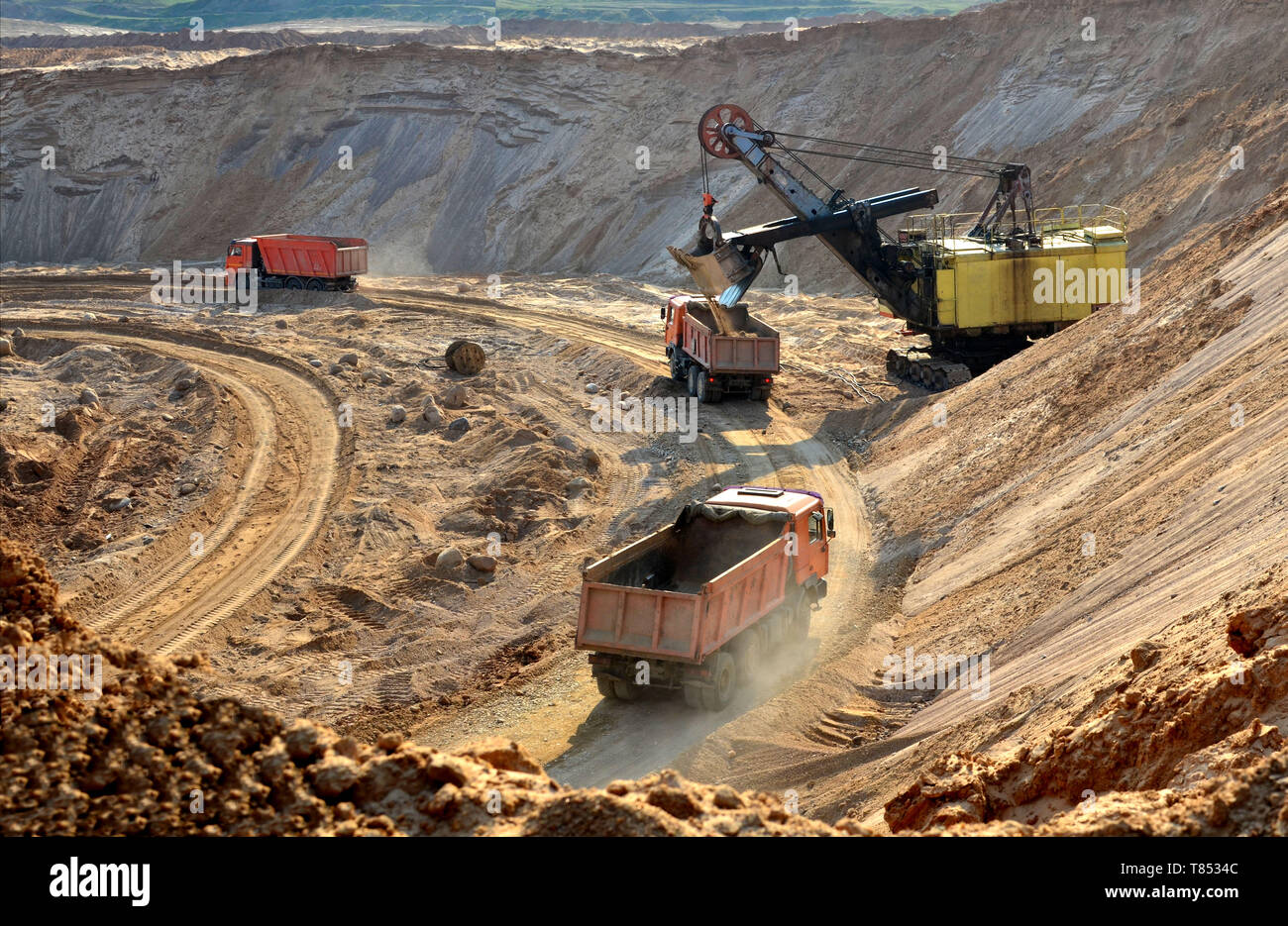 Quarry excavator loading sand or into dump truck at opencast ...