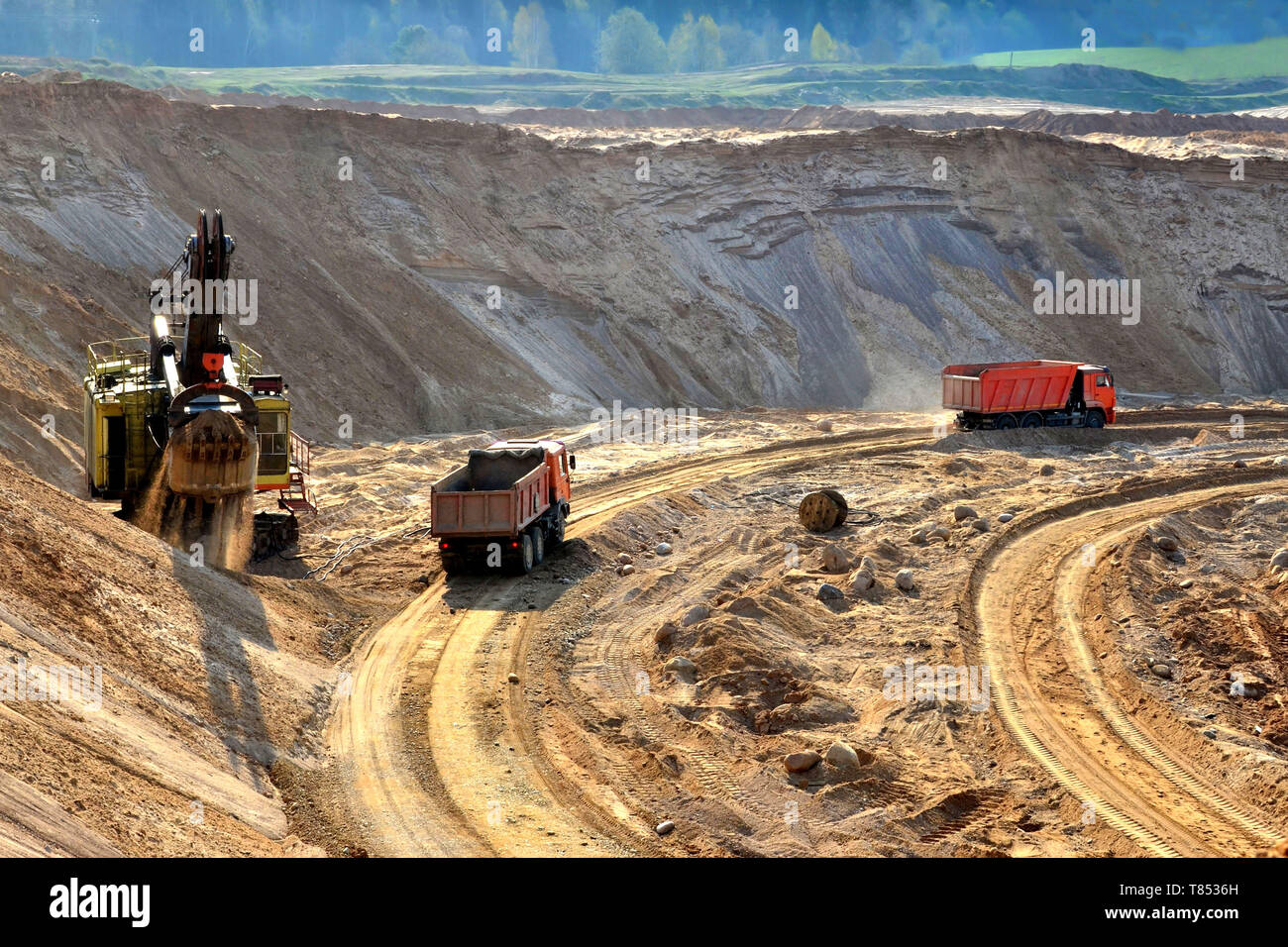 Quarry excavator loading sand or into dump truck at opencast ...