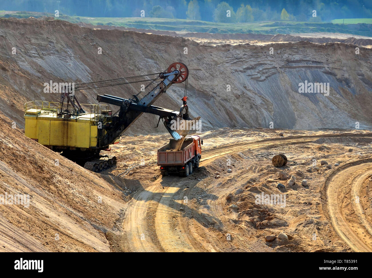 Quarry excavator loading sand or into dump truck at opencast ...