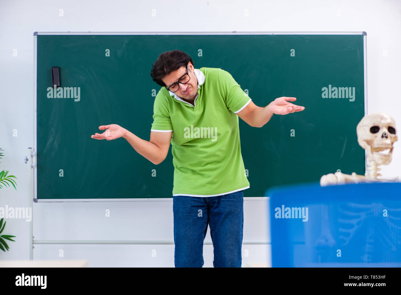 Funny male student in the classroom with skeleton Stock Photo - Alamy