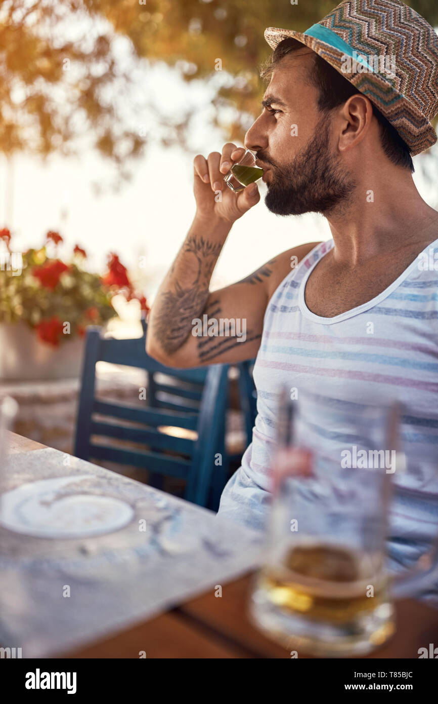 man hipster relaxes and drinking alcohol on vacation Stock Photo - Alamy