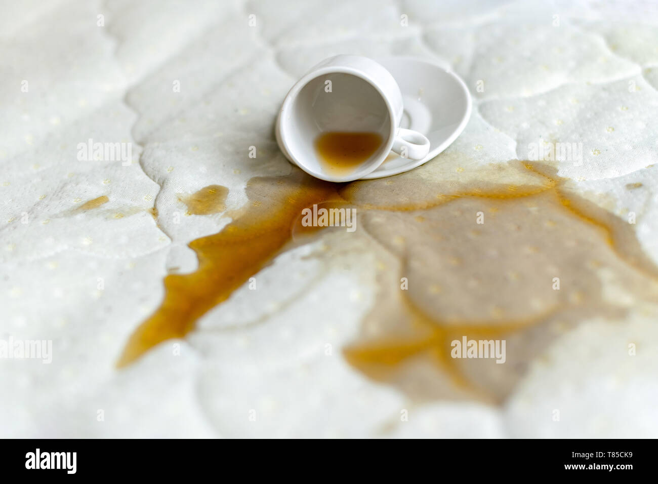 Spilled cup of tea on the bed. Accidentally dropped cup with saucer on ...