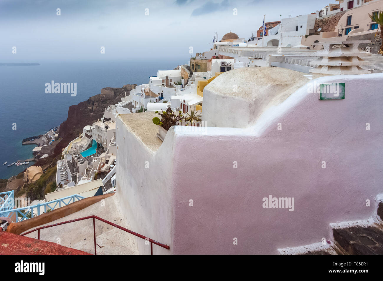 Panorama of white houses of Oia and red cliffs on rainy day, Santorini ...