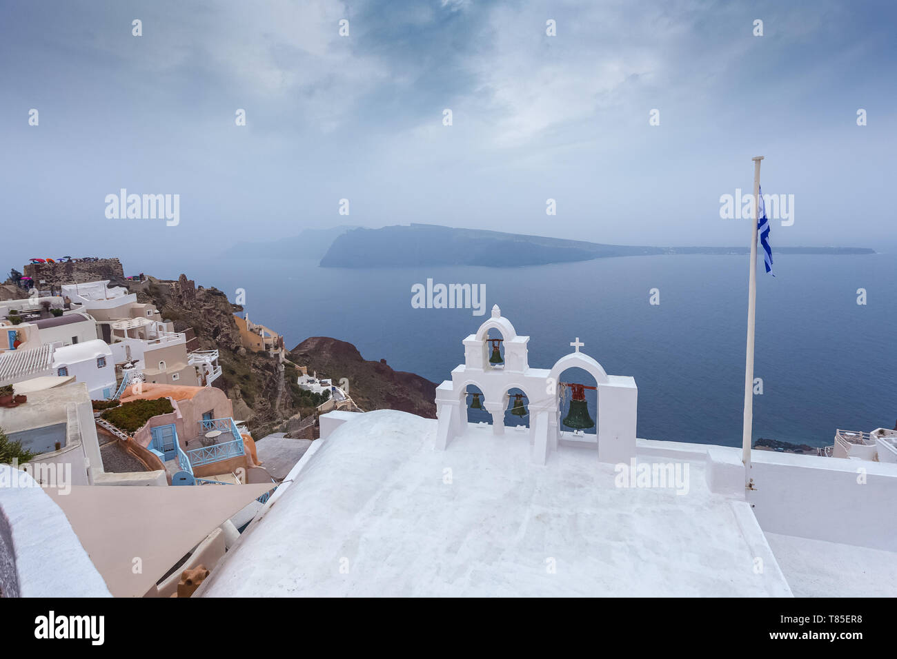 Orthodox church white roof with bells and caldera background, Santorini ...