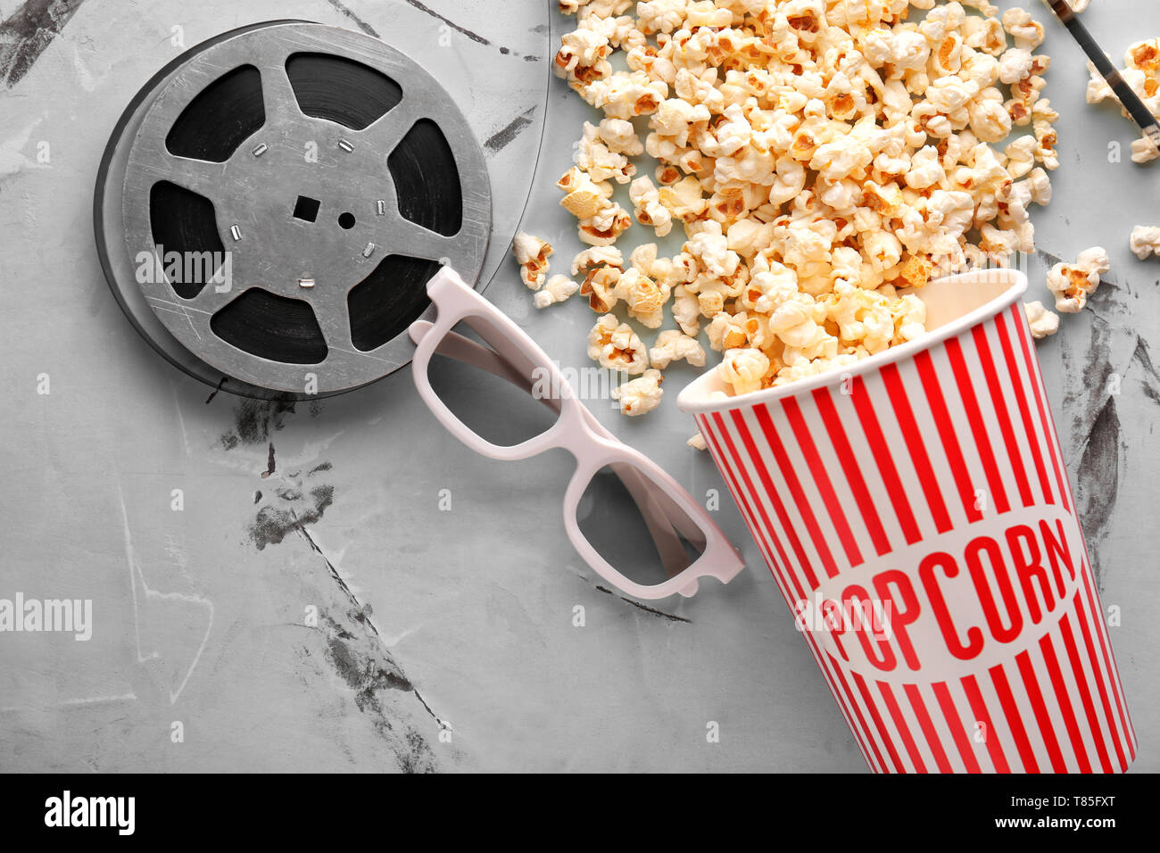 Composition with tasty popcorn and film reel on light background Stock ...
