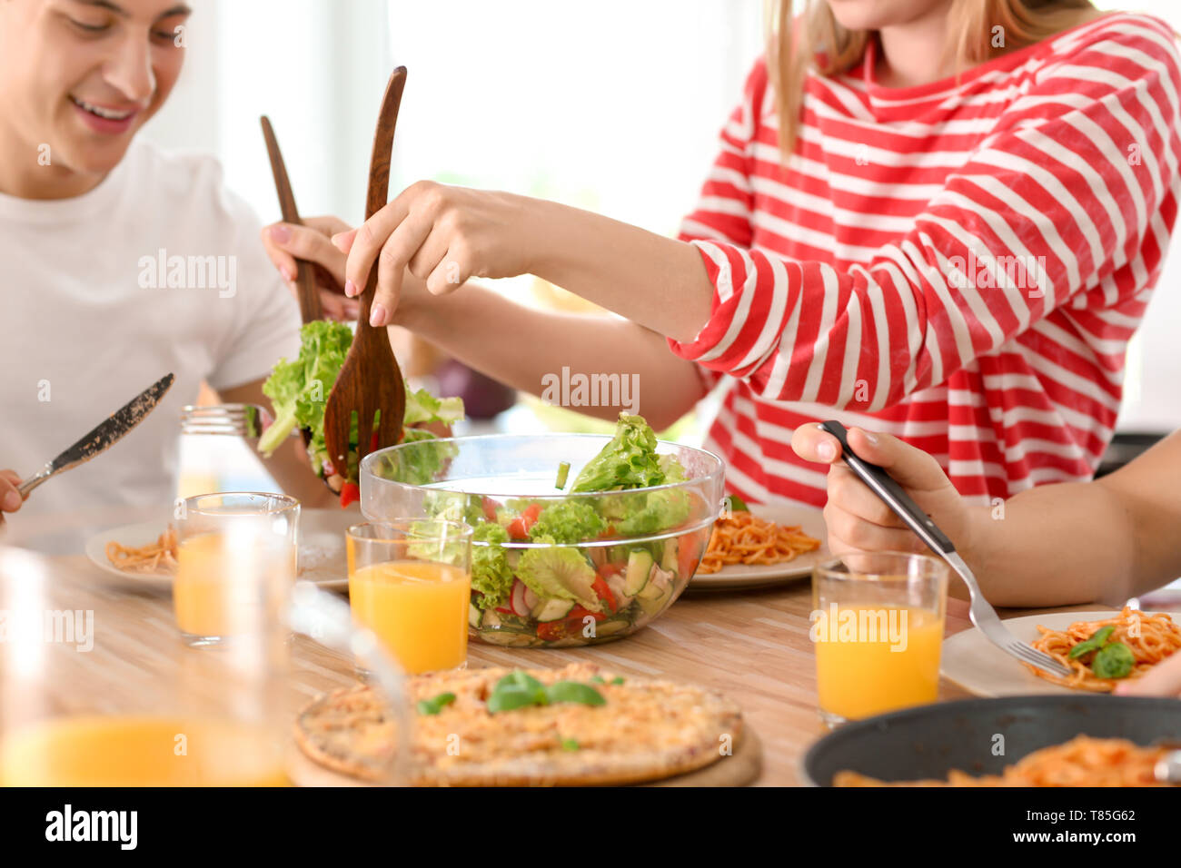 Eating pizza salad friends table hi-res stock photography and images ...