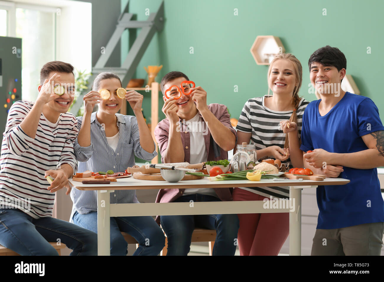 Young friends having fun while cooking in kitchen Stock Photo - Alamy
