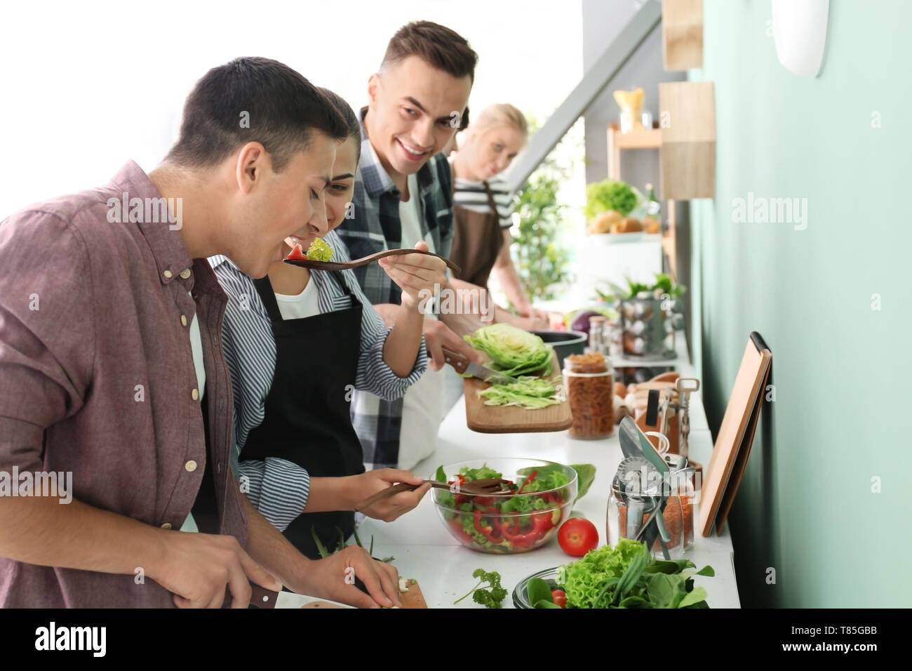 Friends cooking together in kitchen Stock Photo - Alamy