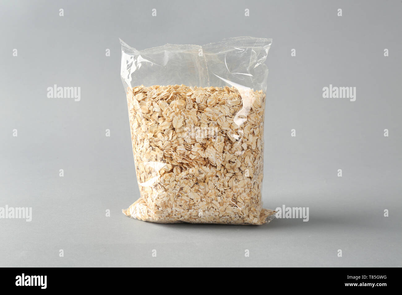 Package with raw oatmeal on light background Stock Photo - Alamy