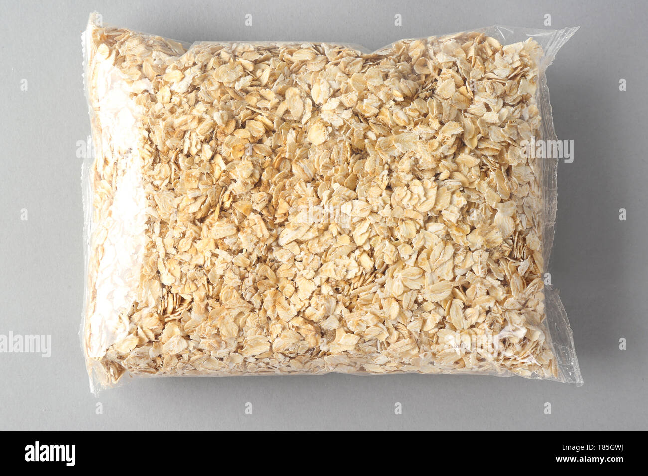 Package with raw oatmeal on light background Stock Photo - Alamy