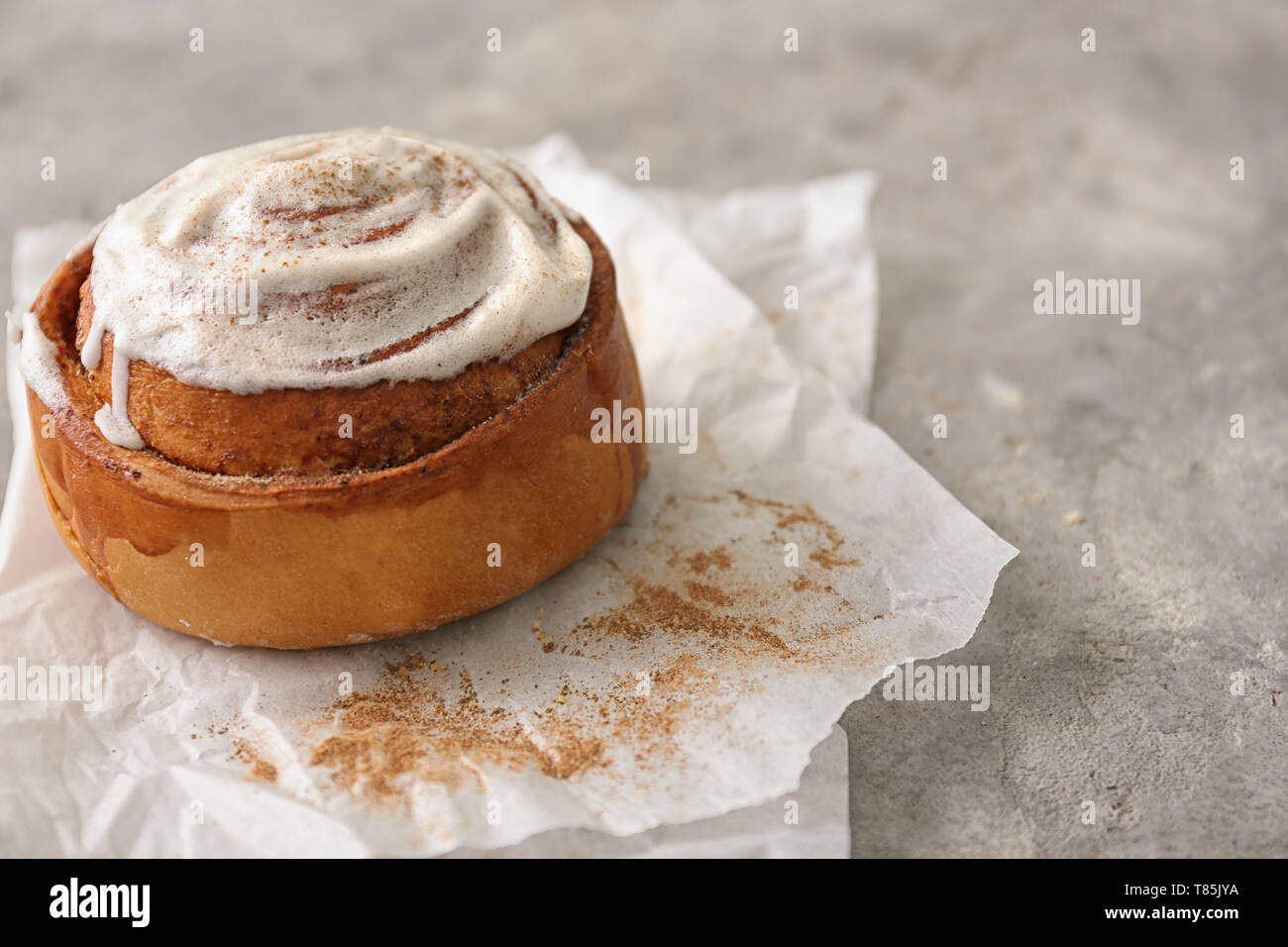 Delicious cinnamon bun on light background Stock Photo - Alamy