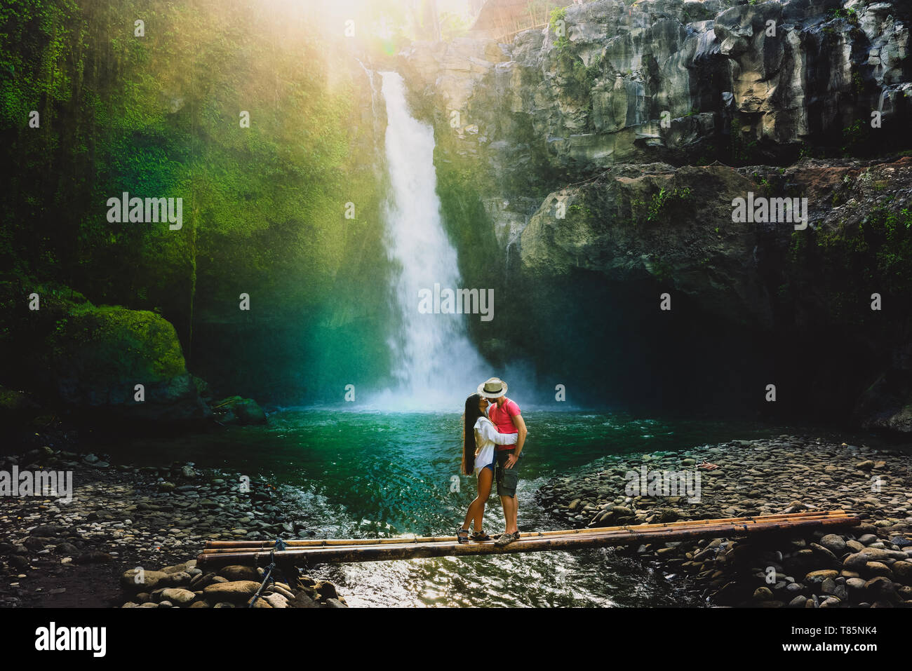 Romantic couple hugging in river under tropical waterfall Stock Photo ...