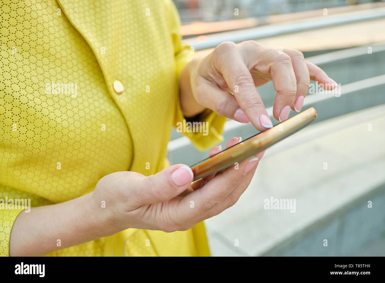 Closeup of womans hand with smartphone, fingers on touchscreen, text ...