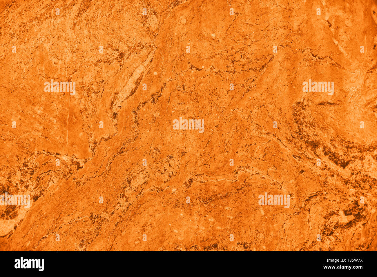 Close up of abstract turmeric orange toned granite stone texture with ...