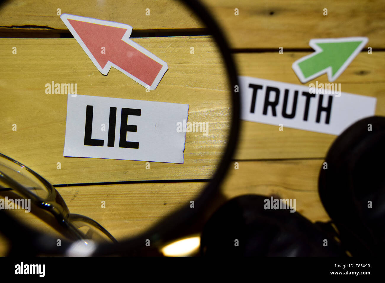 Lie or Truth opposite direction signs in magnifying with sneakers and ...