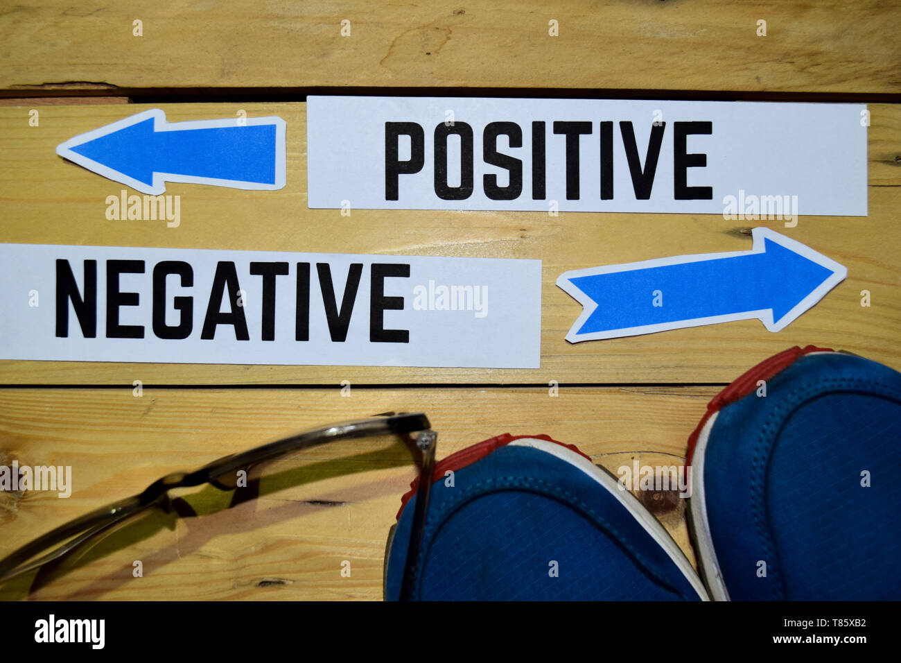 Positive or Negative opposite direction signs with sneakers and ...