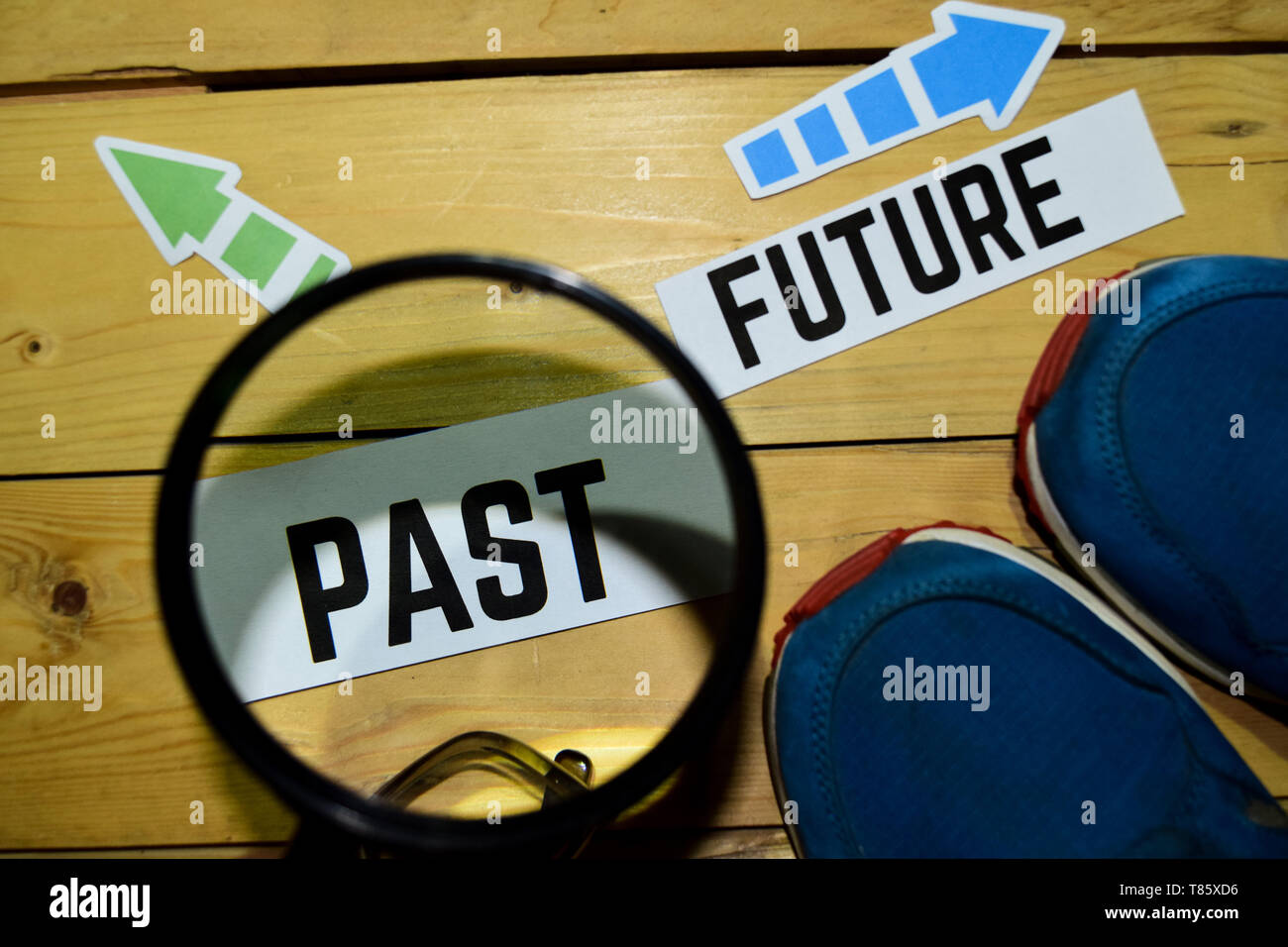 Future or Past opposite direction signs in magnifying with sneakers and ...