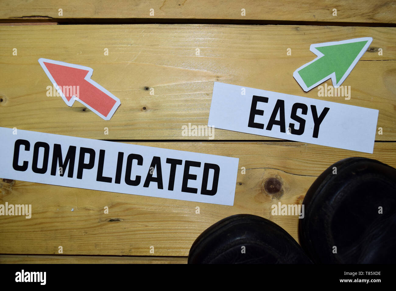 Complicated or Easy opposite direction signs with boots on wooden ...