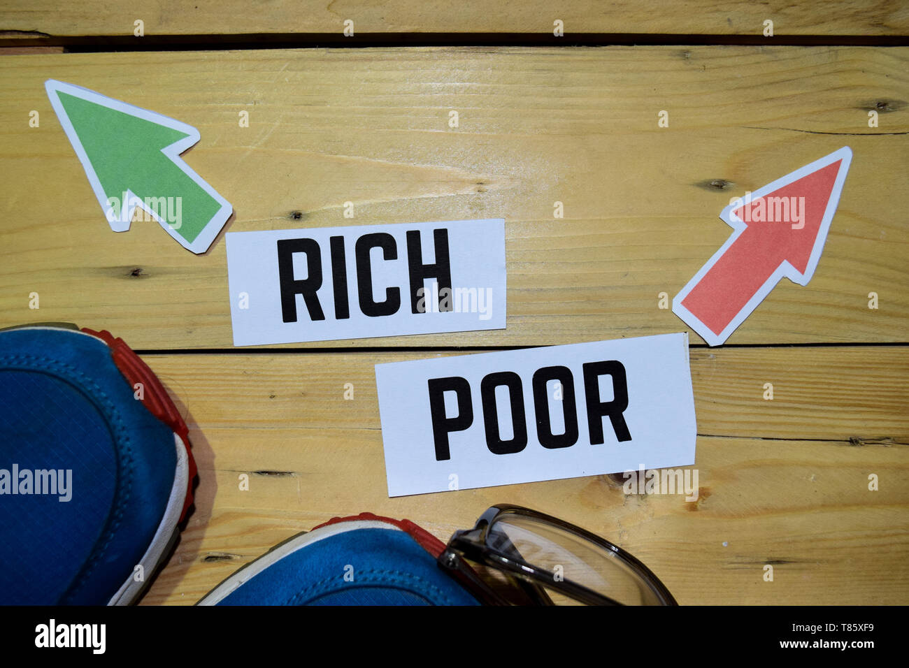 Rich or Poor opposite direction signs with sneakers and compass on ...