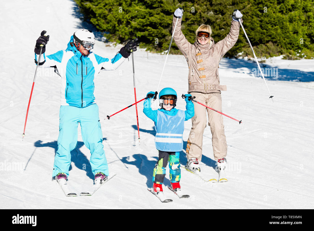 Happy family skiing Stock Photo - Alamy