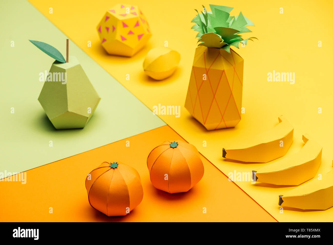 various handmade colorful origami fruits on green, yellow and orange ...