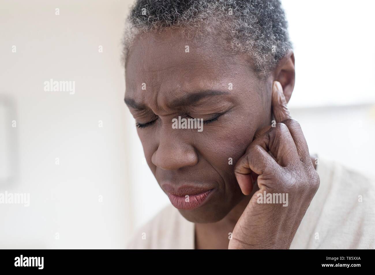 Woman touching ear Stock Photo - Alamy