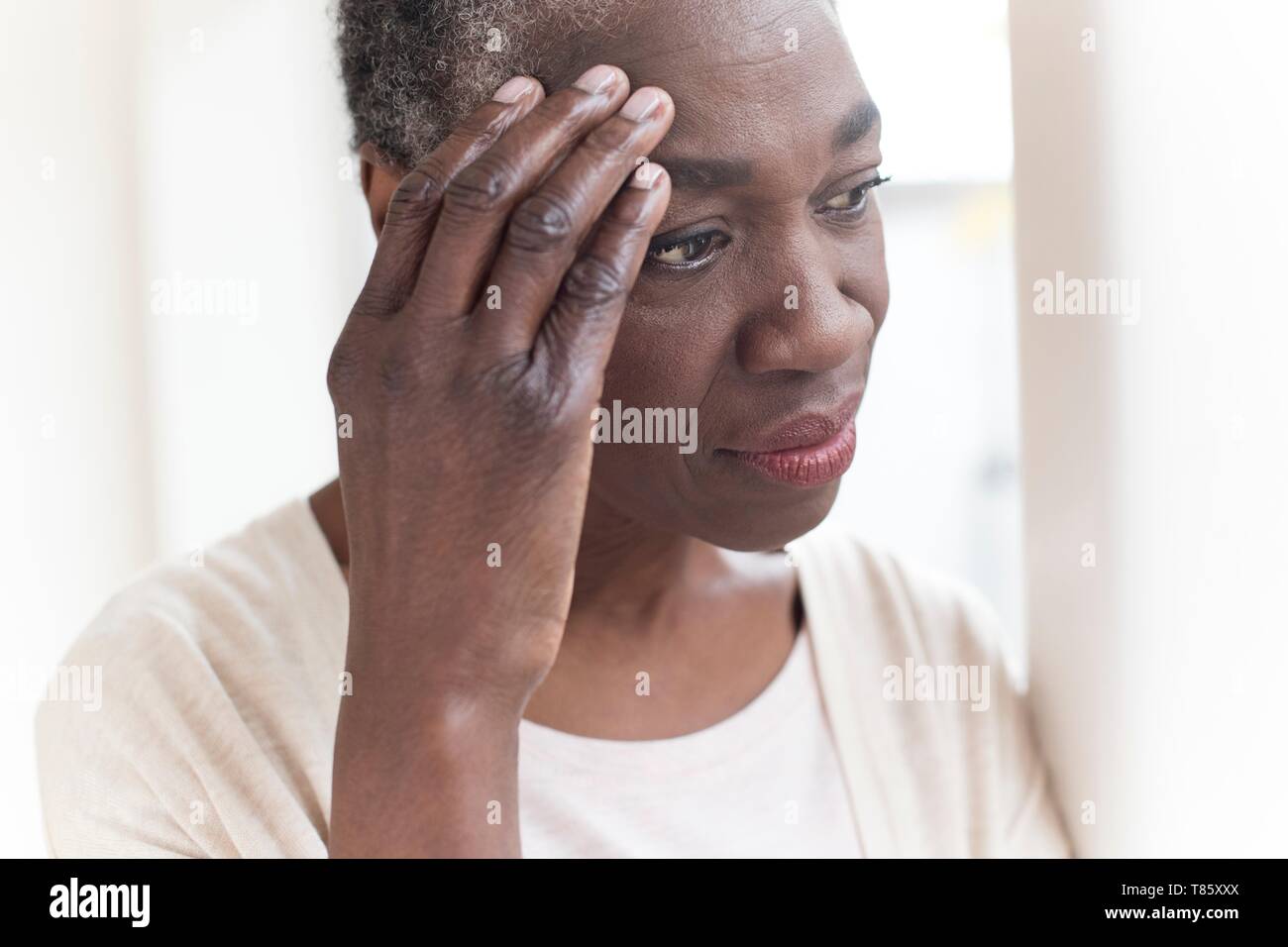 Woman touching head with hand Stock Photo - Alamy