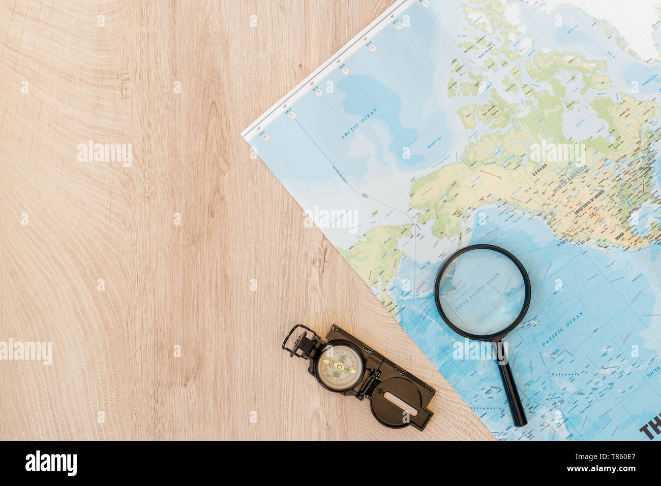 Top view of world map, magnifier and compass on wooden surface Stock ...