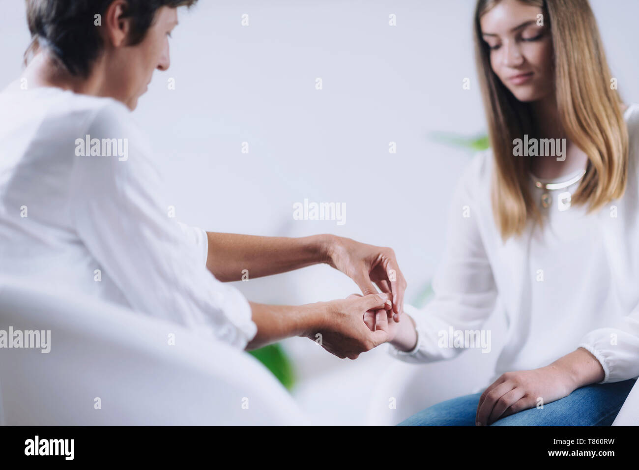 Teenage girl having theta healing therapy Stock Photo - Alamy