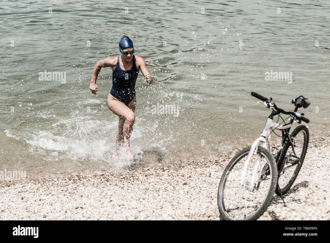 Female triathlete running beach hi-res stock photography and images - Alamy