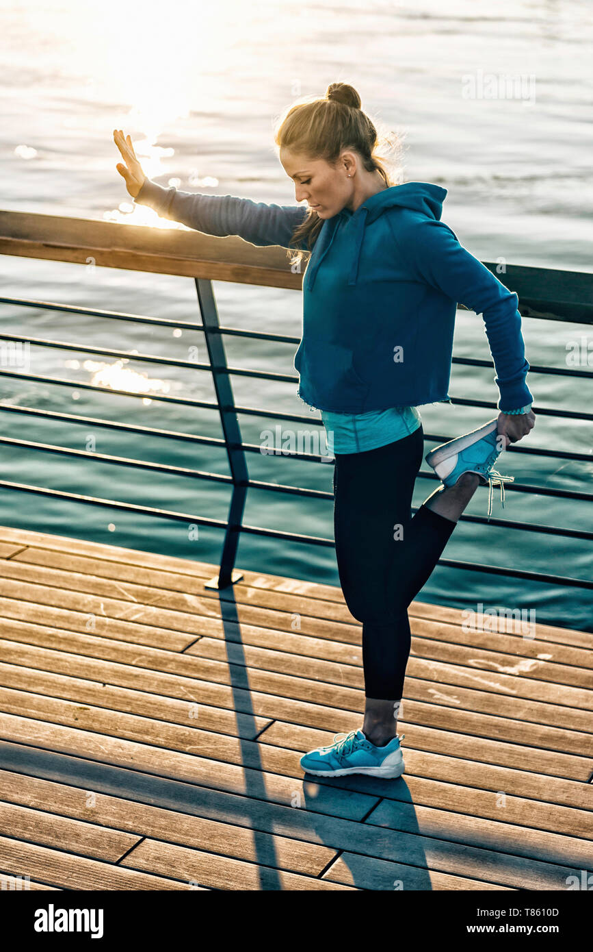 Woman stretching on bridge Stock Photo - Alamy