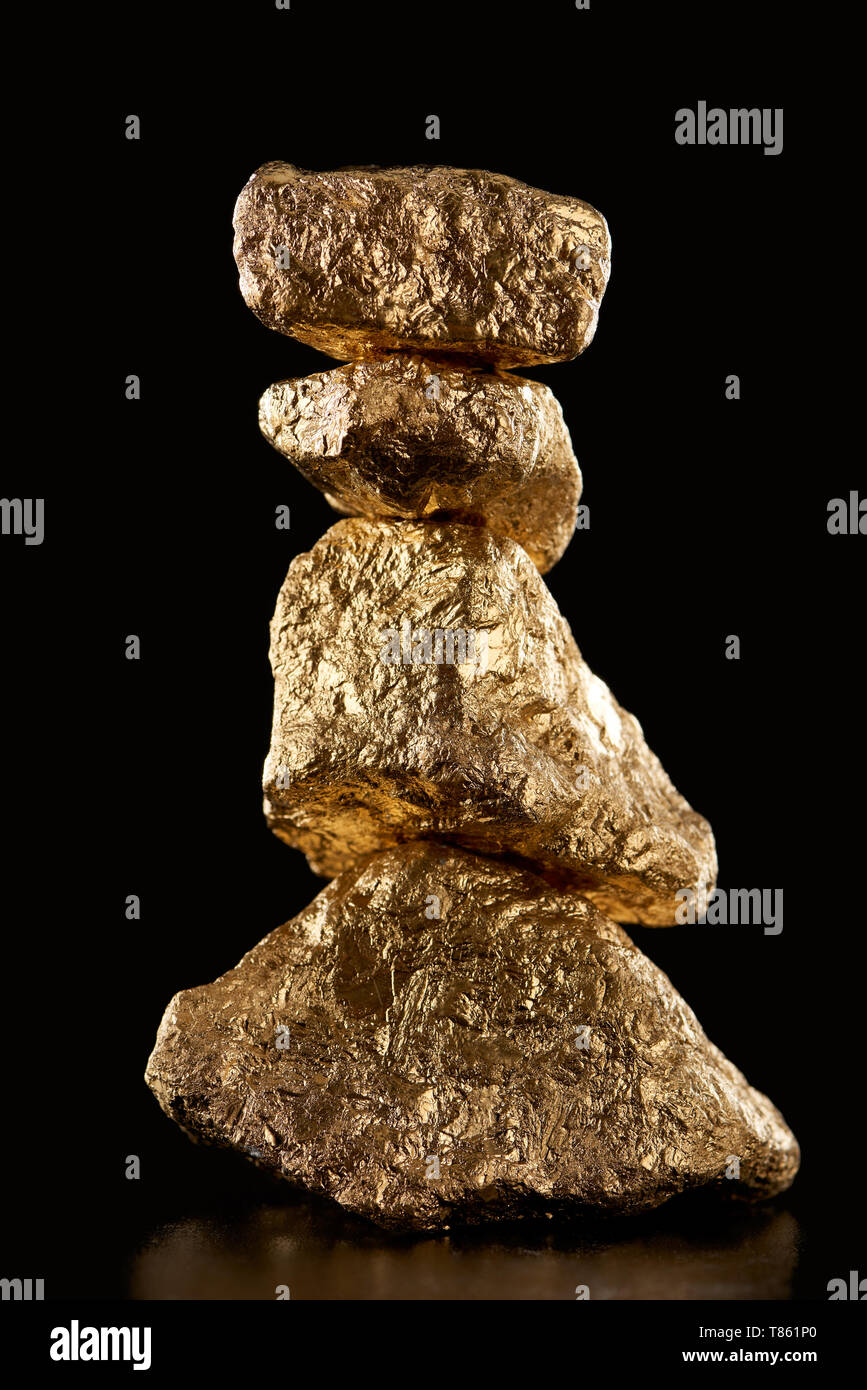 four gold textured shiny stones isolated on black Stock Photo - Alamy