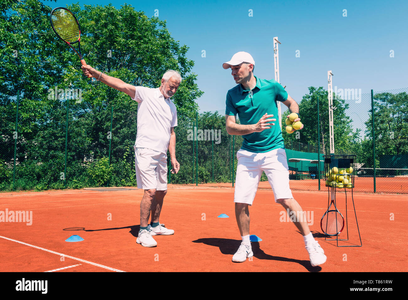 Senior man with tennis instructor Stock Photo - Alamy
