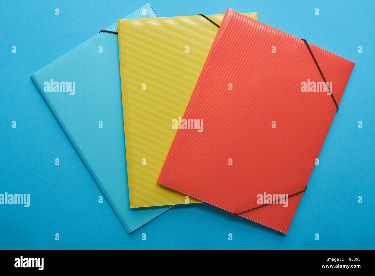 top view of red, blue and yellow paper binders isolated on blue Stock ...