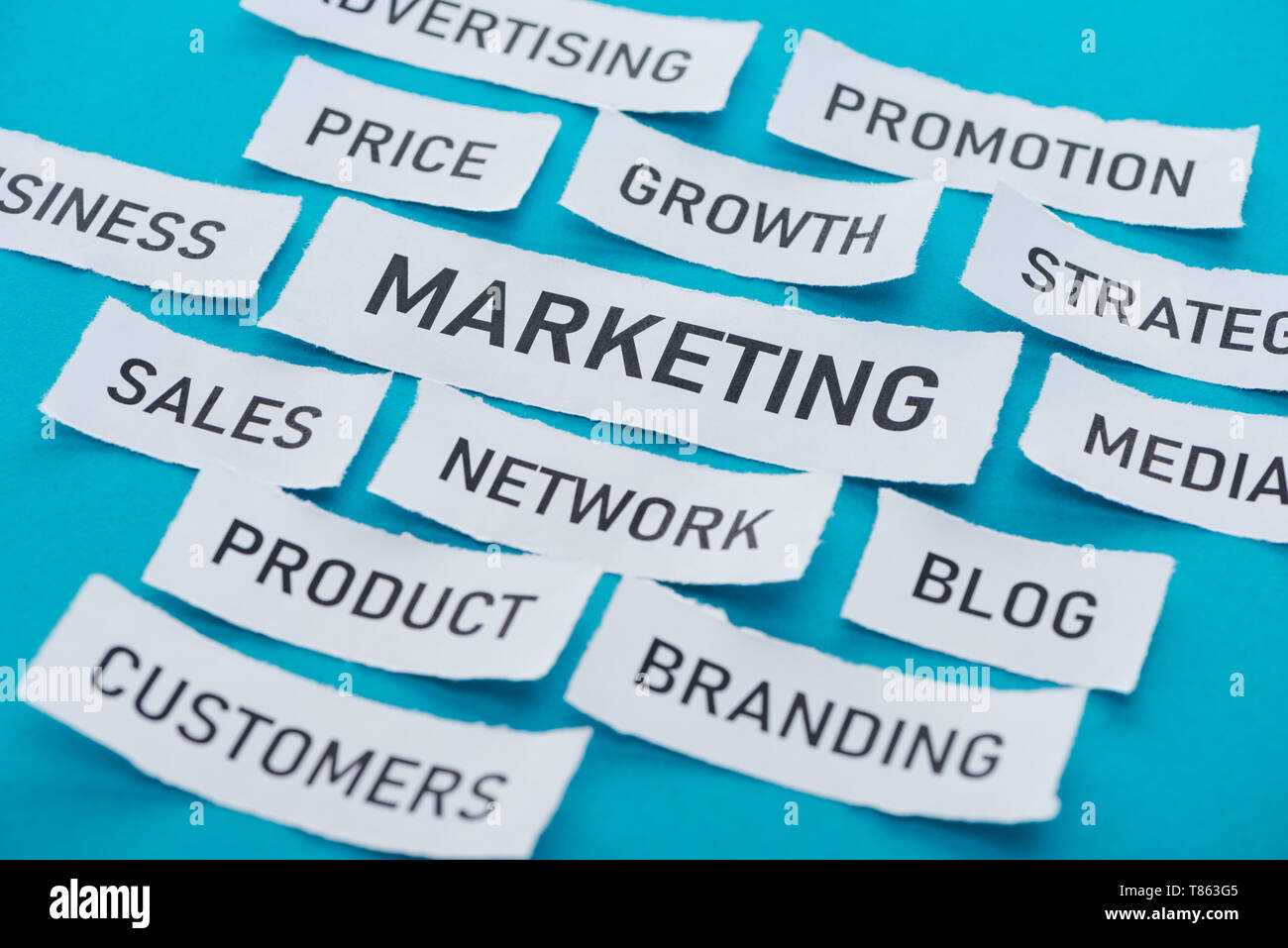 components of marketing on pieces of paper on blue Stock Photo - Alamy