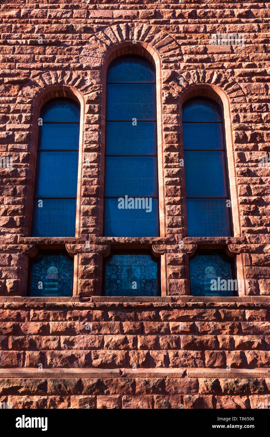 architectural detail of exterior stone wall and stained glass windows ...