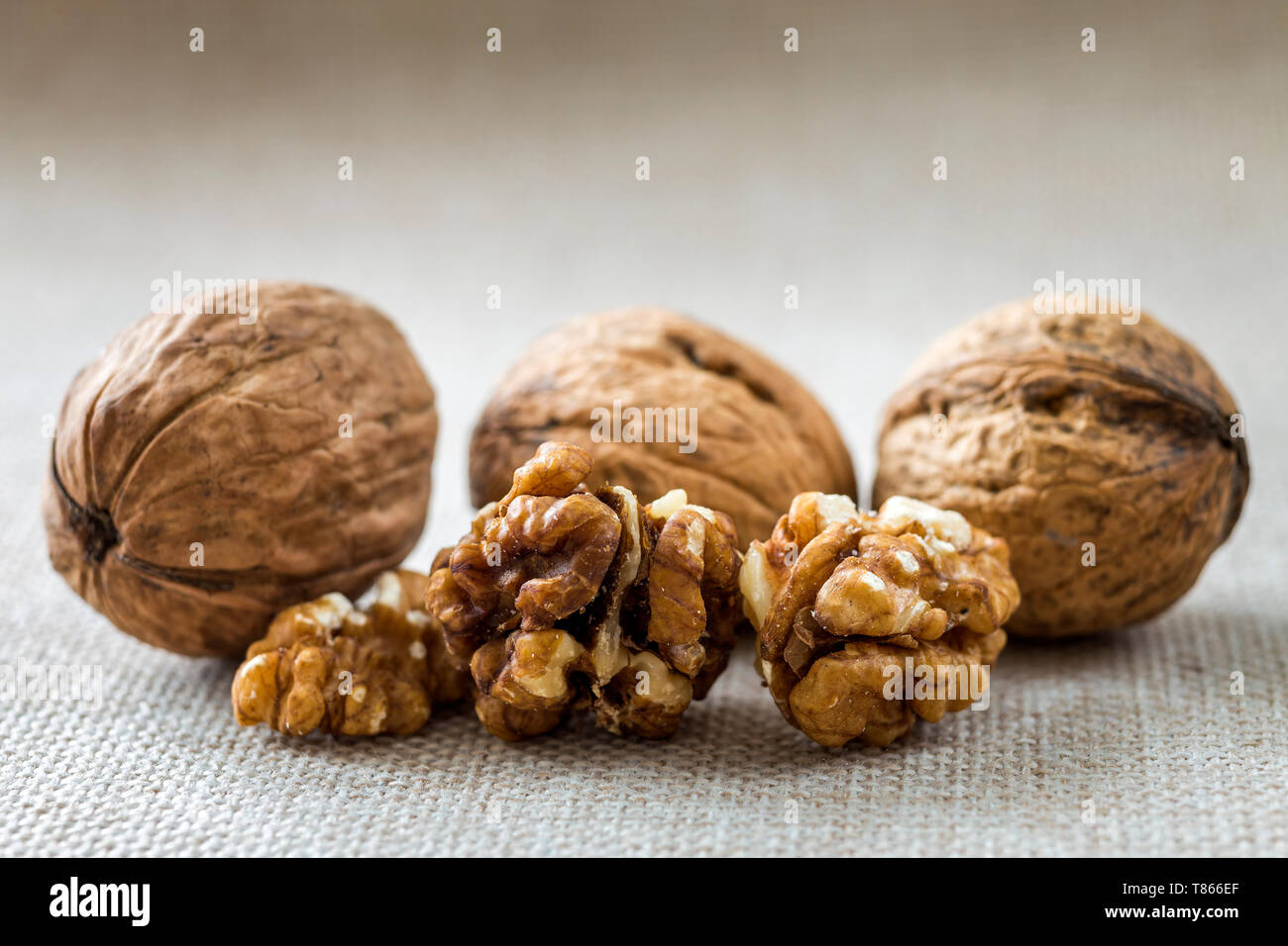 Close-up of walnuts, in wooden shell and kernels isolated on light copy ...
